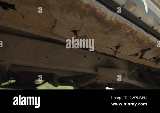 Deep rust on the body of a gray old car. Rust and corrosion hole on old worn out painted metal ...