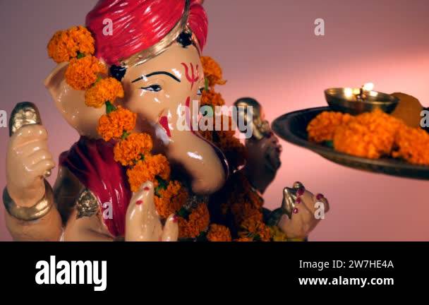 Female hands offering her prayers to Lord Ganesha with an Aarti Thali ...