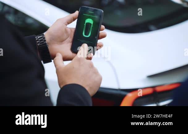 ROME, ITALY - APRIL 28, 2021: Businessman holding smartphone and showing autopilot function of ...