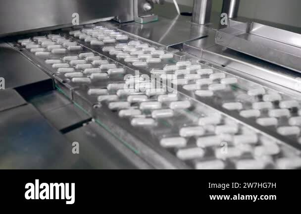 Batches of capsule meds are getting relocated by a conveyor Stock Video ...