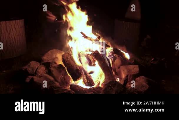 A fire is burning in a fireplace made of stones. The concept of tourism ...