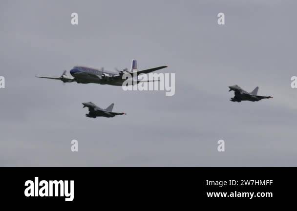 Four-engine propeller airliner of 1950s in flight with two modern ...