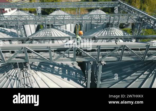 The engineer inspects the grain processing and storage elevators. An employee of an agricultural ...
