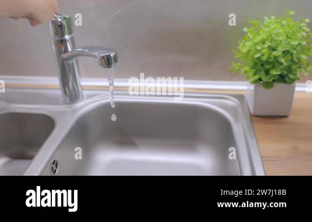 Tap water flows from the tap. Drinking water at the tap. Faucet in the ...