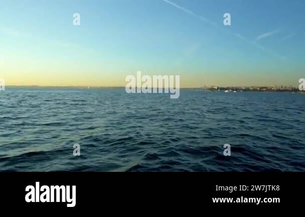Aerial drone view of the blue sea. The city is visible on the horizon ...