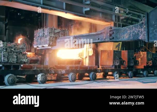Industrial mechanism is transporting copper materials into a furnace ...