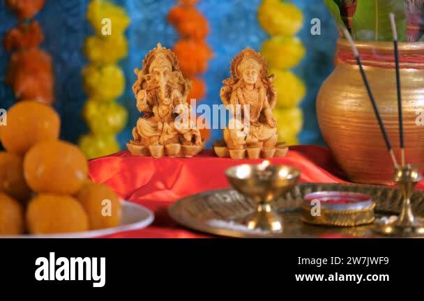 Lady offering marigold flowers to Lord Ganesha and Devi Laxshmi on ...
