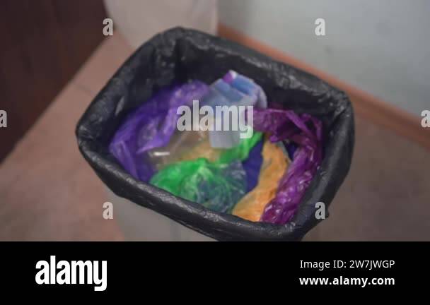 A woman throws broken wires in a regular trash bin. Improper disposal ...