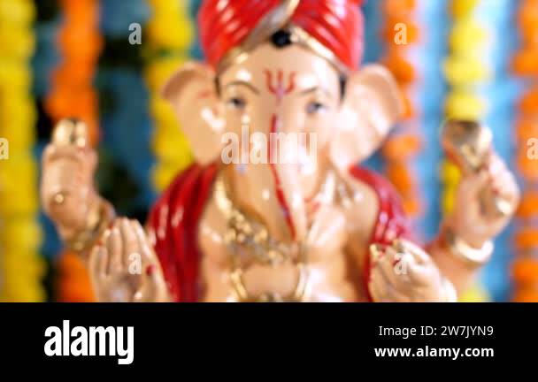 Lord Ganesha statue decorated with orange and yellow marigold flowers ...