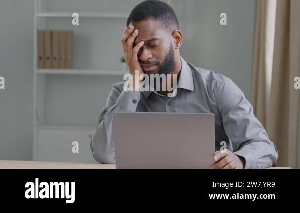 Anxious stressed tired young African American male employee manager or ...