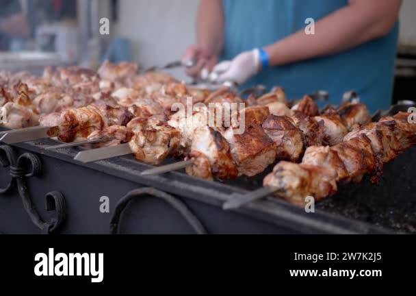 Chef Cooking Juicy Pork Kebab on Open Grill in a Food Court on a Metal ...