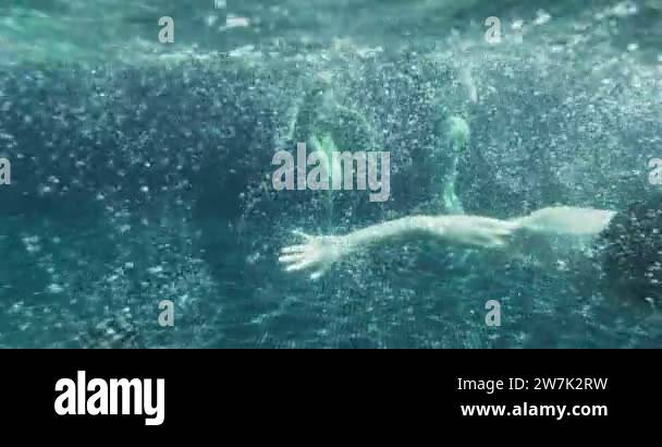 Friends swimming in the pool underwater and having fun celebrating ...