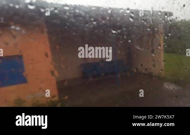 Shooting a rural landscape through the wet glass of a railway carriage ...