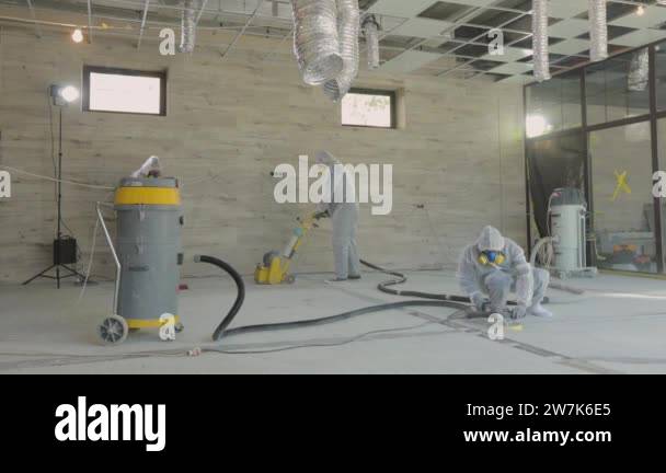 Concrete surface grinding. Builders at a construction site. Builders ...