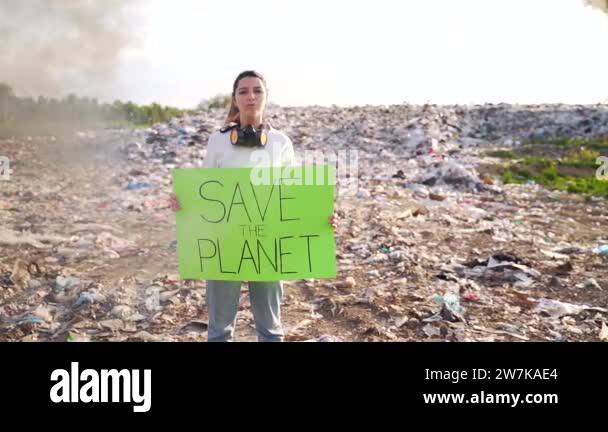 young woman activist with a poster in hands save the planet stands ...