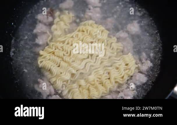 Food boiling in hot water to boil noodles and meat before serving to ...