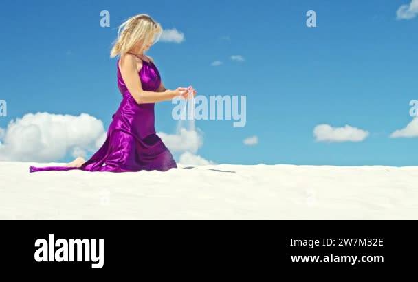 Cinematic slow motion of a woman who drew sand from her hands while ...