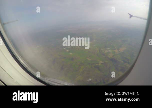 Passenger looking through window of plane shaking in turbulence. Air ...