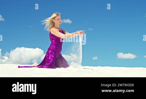 Cinematic slow motion of a woman who drew sand from her hands while ...
