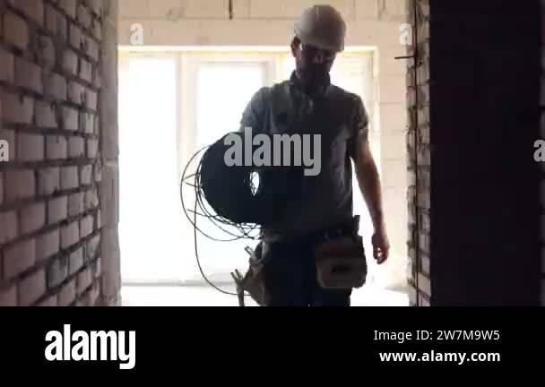 Construction worker putting on his safety gear helmet at the job site ...