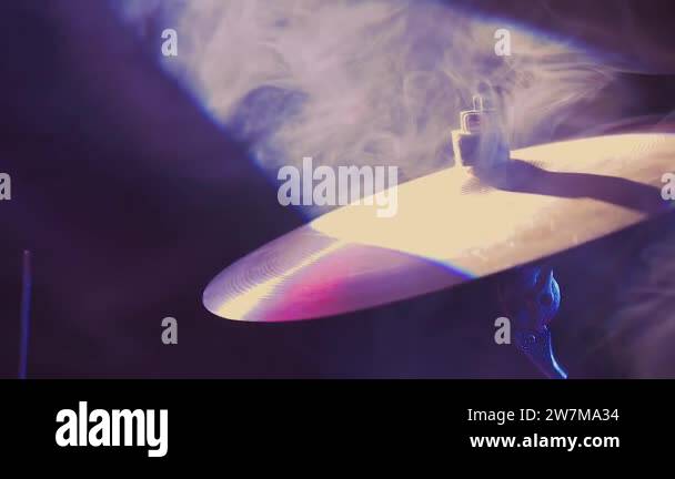 musician hits the cymbal with his drumsticks and the vibration scatters ...