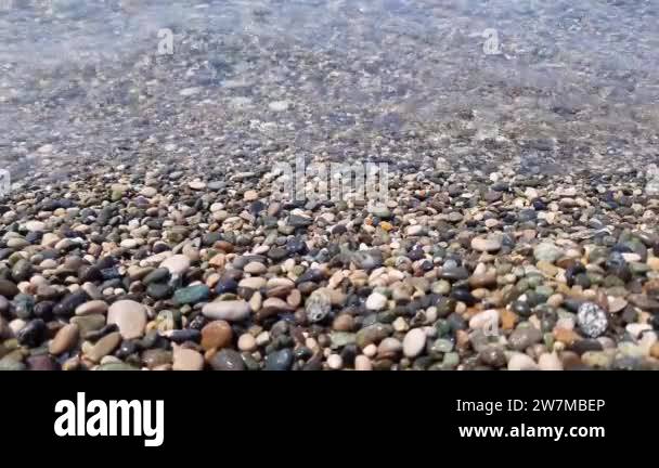 Clear sea waves over pebbles beach. Side view Stock Video Footage - Alamy