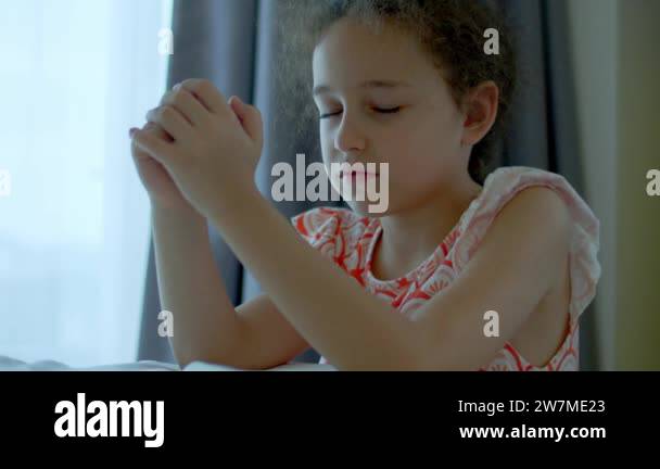 Little girl is praying in her room.Close up portrait of child concept ...