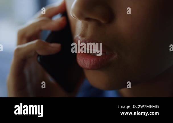 African american businesswoman face talking mobile phone. Girl biting ...