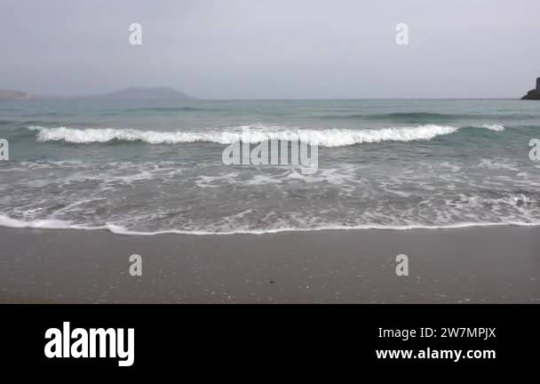 Unhurried waves of the Black sea run on the sandy shore. Calm cloudy ...