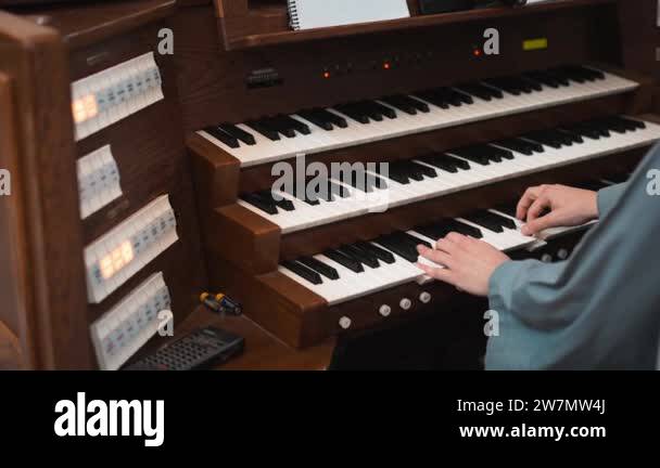 Back view of church nun playing piano music in cathedral during wedding ...