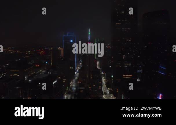 Backwards reveal of illuminated streets and modern tall buildings ...