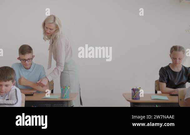 Female teacher controlling learning process in primary school. A female ...