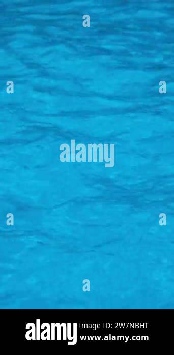 Pure transparent blue water in the swimming pool with light reflections ...