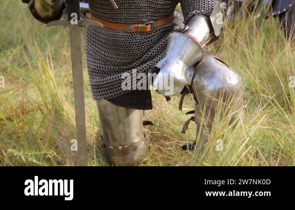 A knight in a full set of medieval armor and with a bandana on his head ...