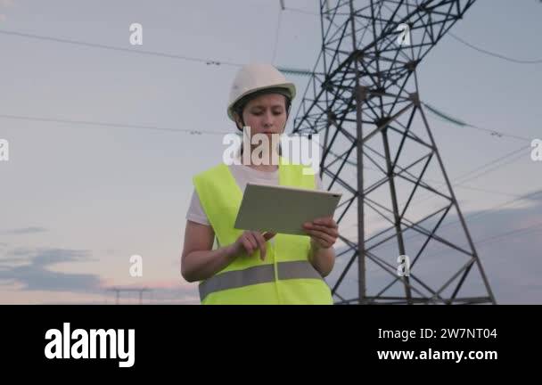 an electrician works with a tablet at a large power plant supplying ...
