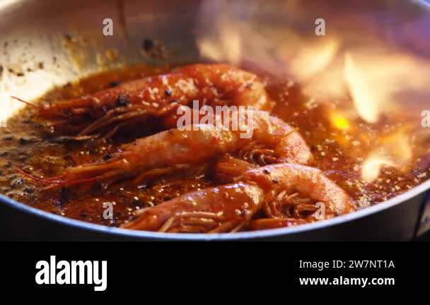 Grilling fresh red king prawns on pan with hot flame in slow motion at ...