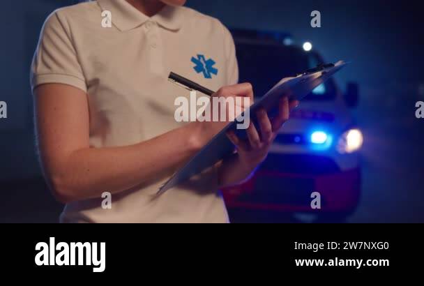 Close up of Caucasian female paramedic writing with pen in hand in ...