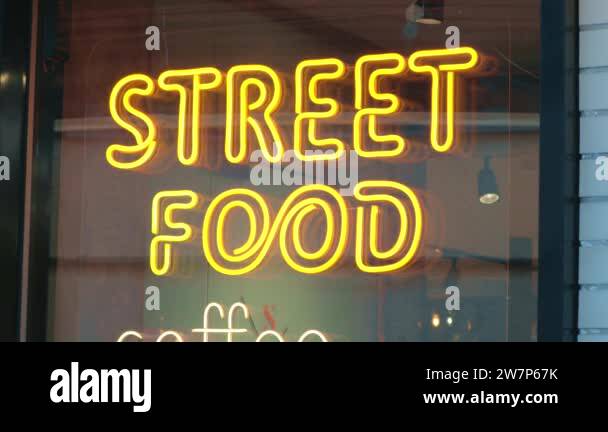 neon street food sign on the restaurant's windows case.concept street ...