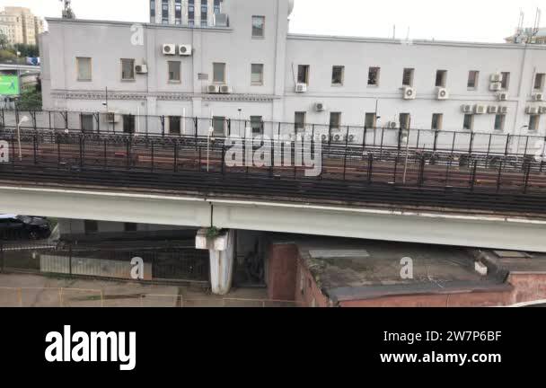 The metro train is moving along the overpass between the buildings ...