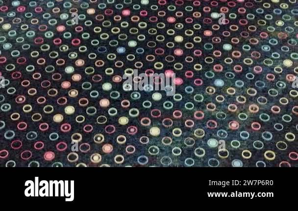 Moving surface with many small round shaped silhouettes and colorful ...