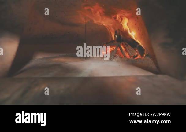 A wood-burning stove, a stone wood-burning stove, logs burn inside a ...