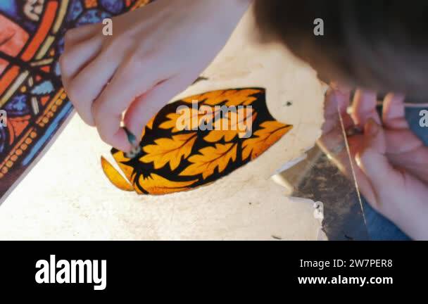 The artist is working on the creation of a stained glass window, top ...