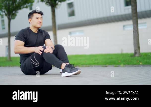 young asian runner athlete with muscle pain. Man massaging Stretching ...