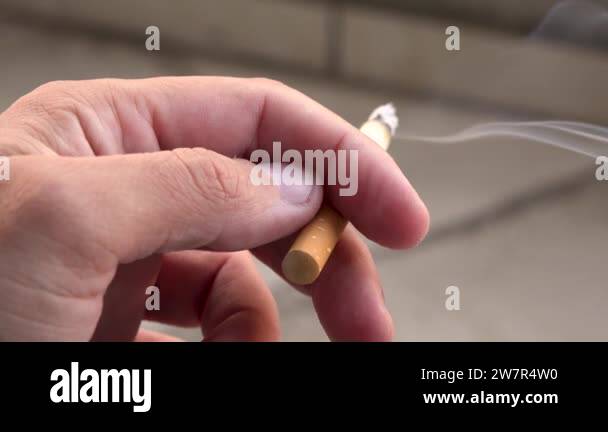 Close up of male hand with burning cigarette. Concept of dangers of ...