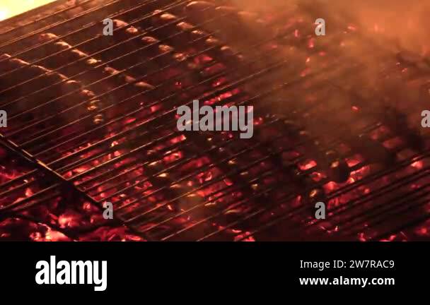 Zoom barbecue sausage merguez on red and orange charcoal embers on a ...