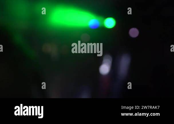 Neon lights on the dance floor. Blurry bokeh. People are jumping on the ...