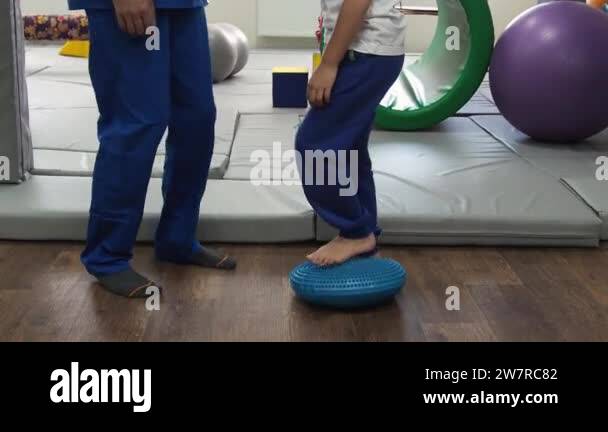 Kid girl with therapist do exercise on touch pad foot massager during ...