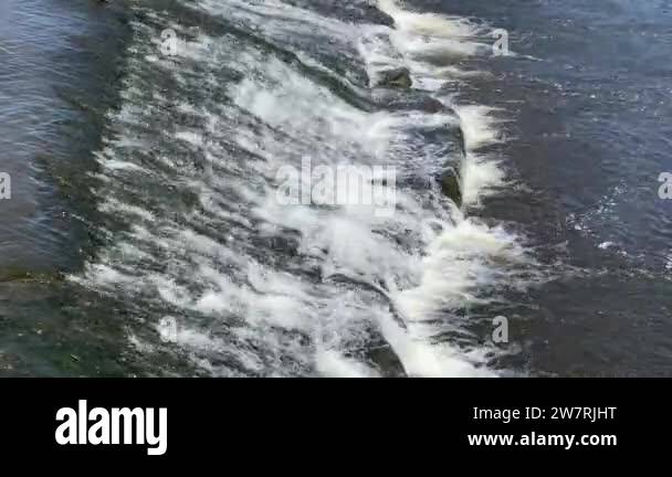 Water flowing over a gently sloping weir on a river. No people Stock ...