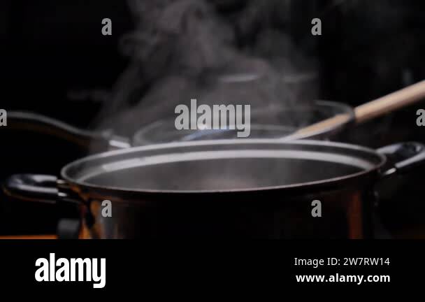 Steam rising from boiling water in a pot on the stove. Vapour or white ...