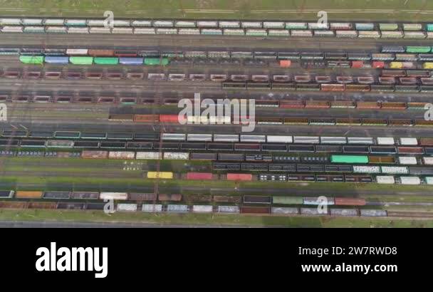 Fly over a large railway junction. Freight trains stand at the railway ...